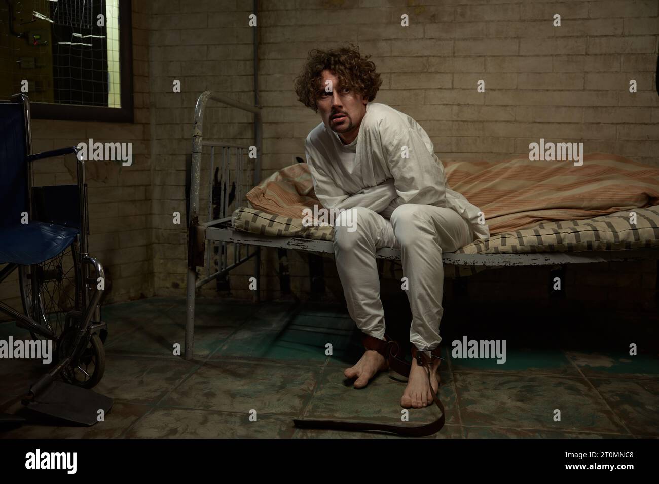 Crazy psycho man wearing straitjacket sitting on hospital bed Stock ...
