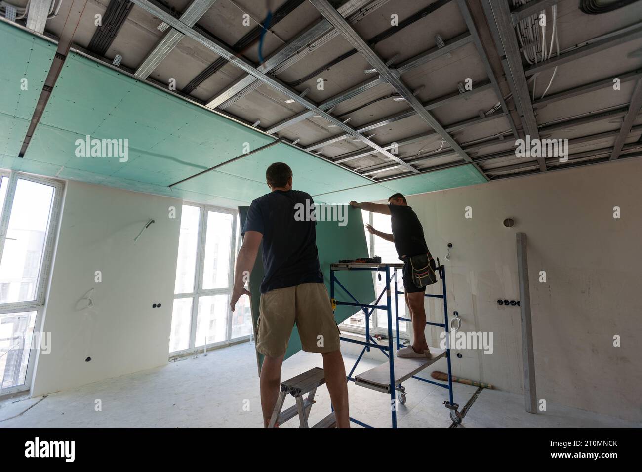 Construction worker ceiling work installation Stock Photo - Alamy