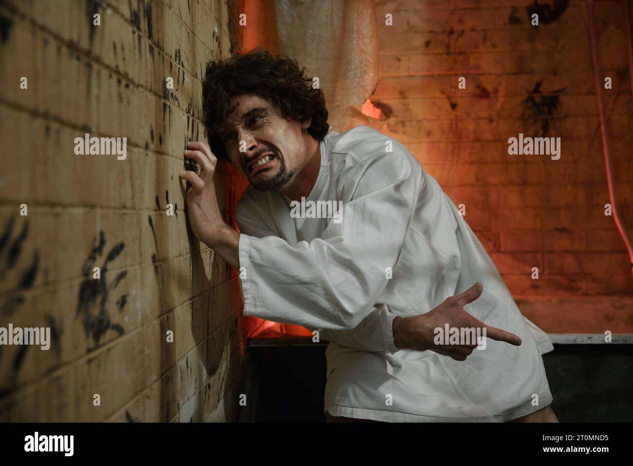 Crazy prisoner or psychiatric hospital patient scratching wall with ...