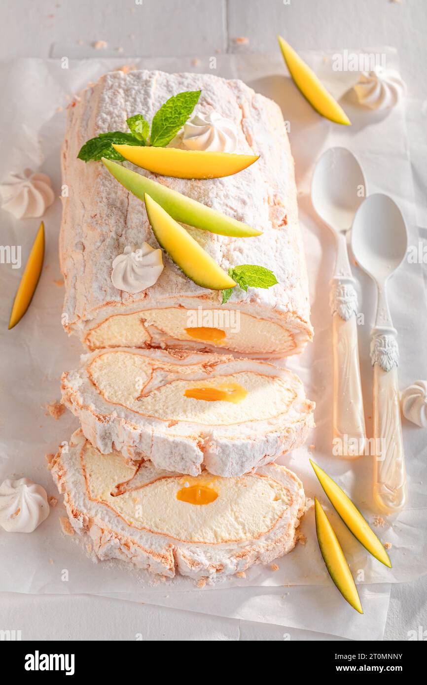 Sweet mango swiss roulade with fruits and powdered sugar. Swiss roll ...