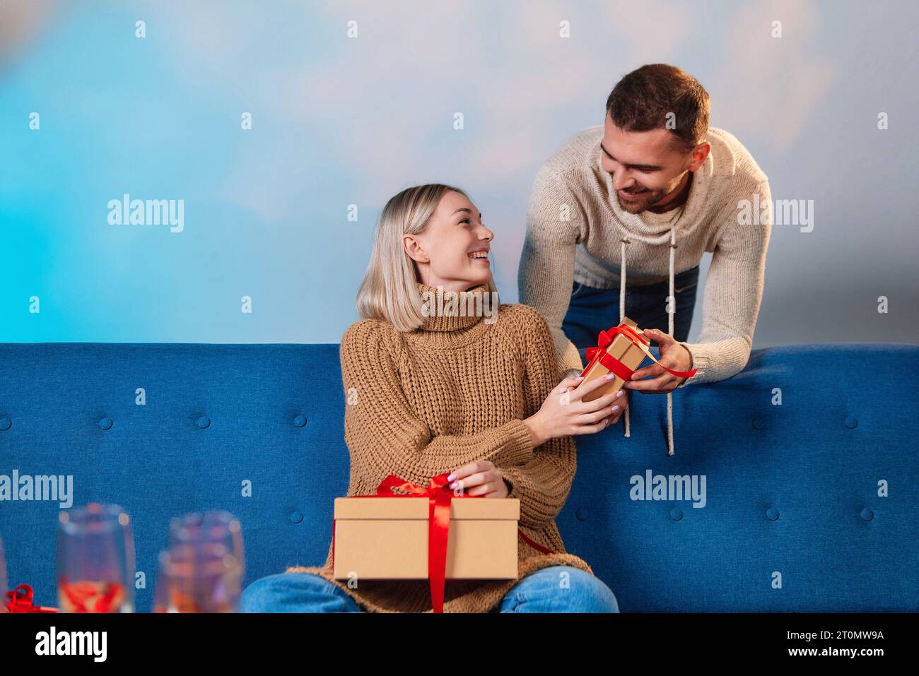 Gift exchange. A loving couple celebrates Christmas. Home holiday. Boy ...