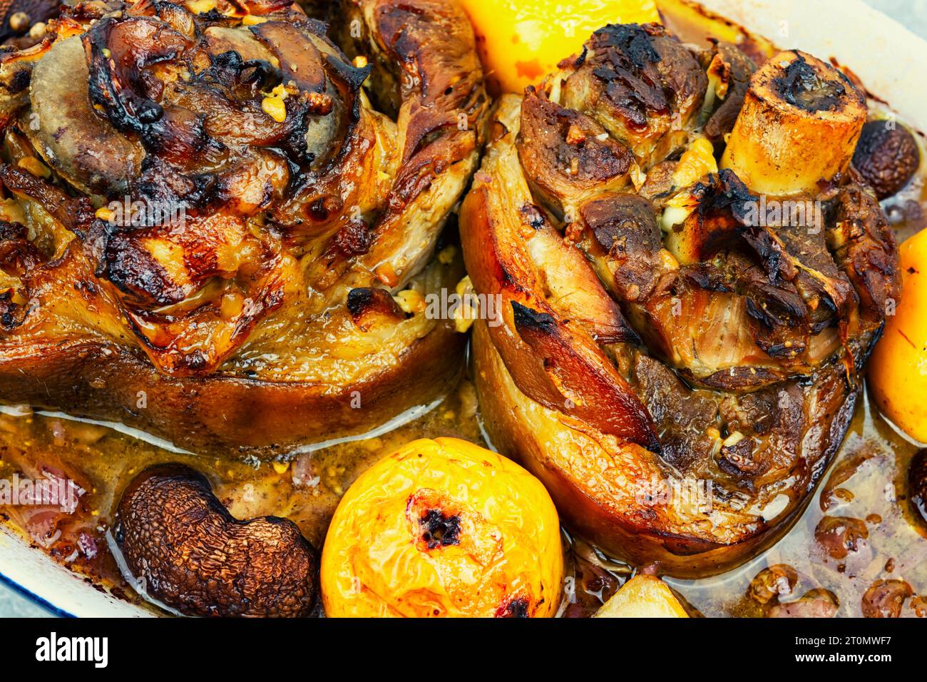 Traditional pork knuckle cooked in dark beer, sauerkraut and apples ...