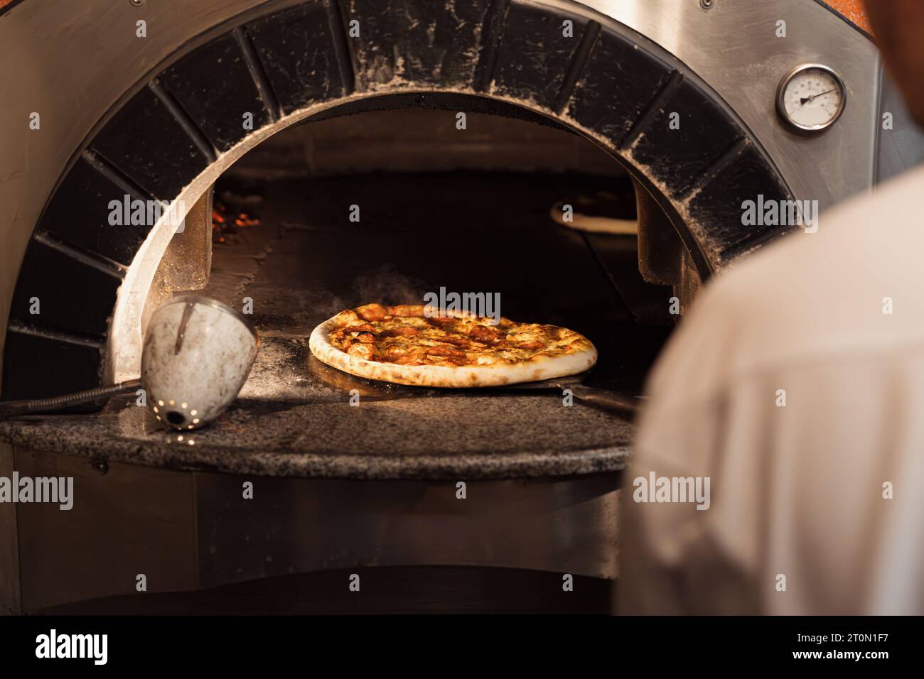 Preparing traditional italian pizza in a professional oven with open ...