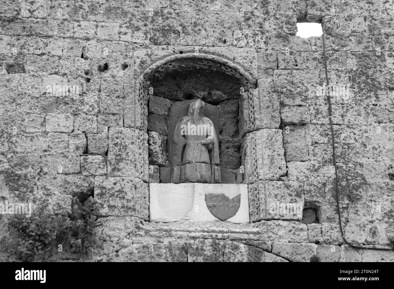 Black and white person statue on a brick wall at the medieval city of ...