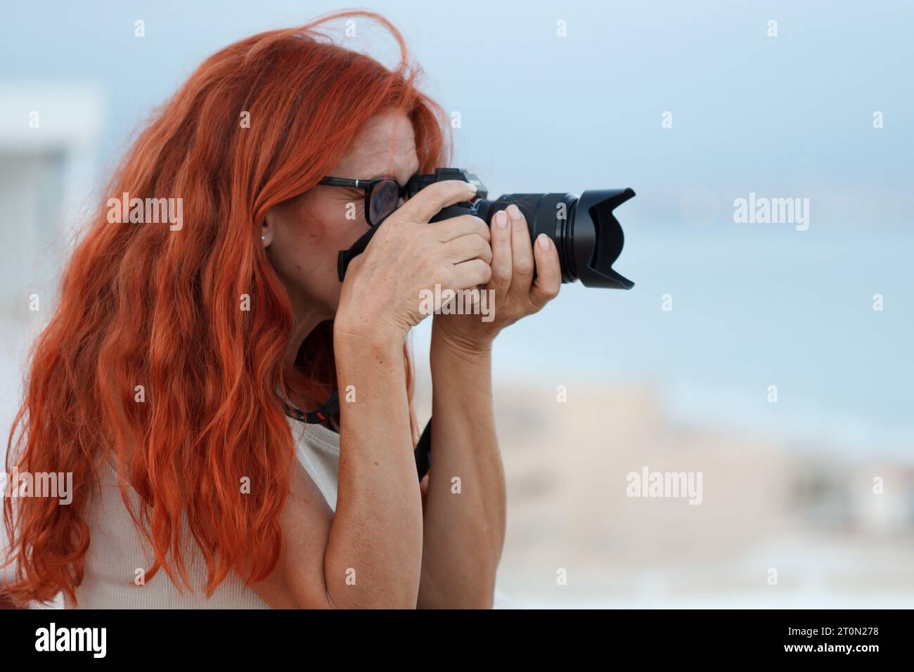 Redhead woman with backpack and camouflage clothing executing landscape ...