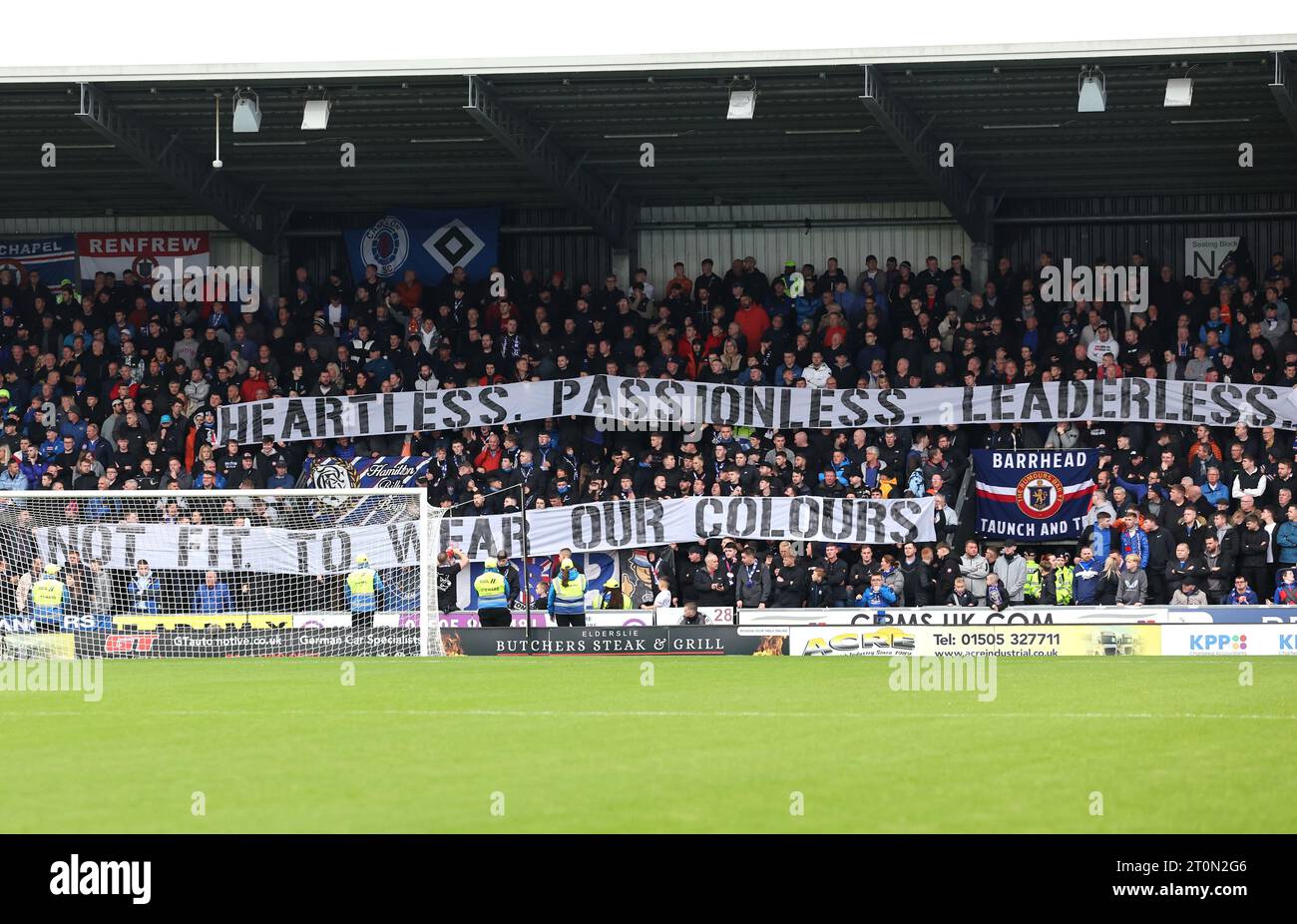 Rangers fan holds up a large banner saying 'Heartless. Passionless ...