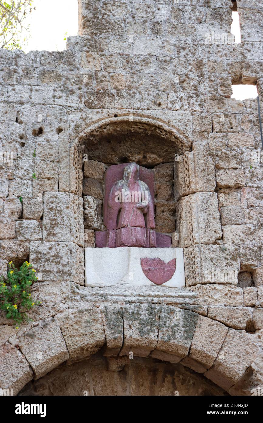 Red person statue on a brick wall at the medieval city of Rhodes ...