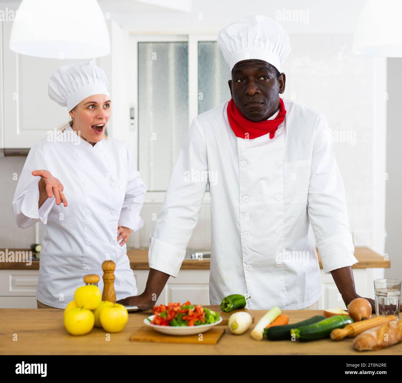 Chefs in white uniform having conflict on kitchen Stock Photo - Alamy