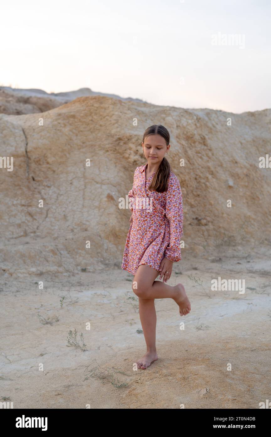 A beautiful teenage girl walks barefoot on a country holiday day off ...