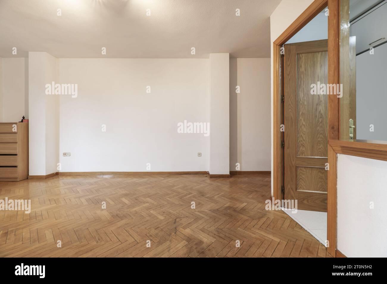 Living room of an empty house with parquet floors and a small kitchen ...