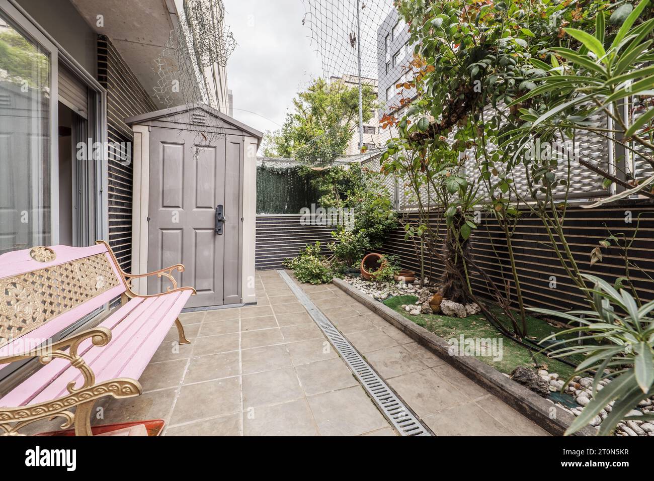 A terrace on the ground floor of a residential building with trees ...