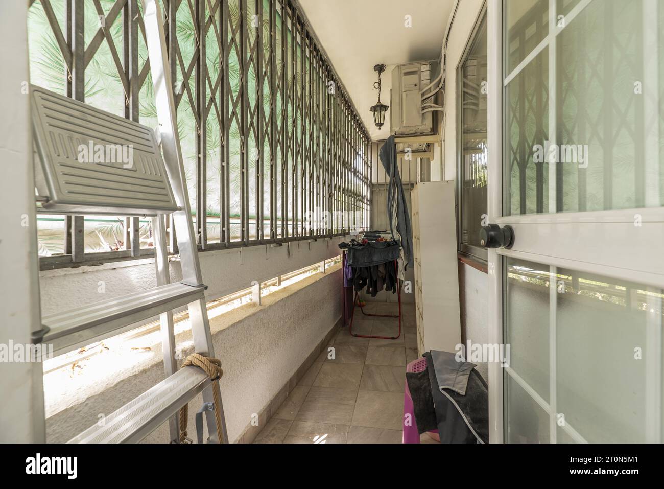 Closed terrace with folding metal bars, gray stoneware floor Stock ...