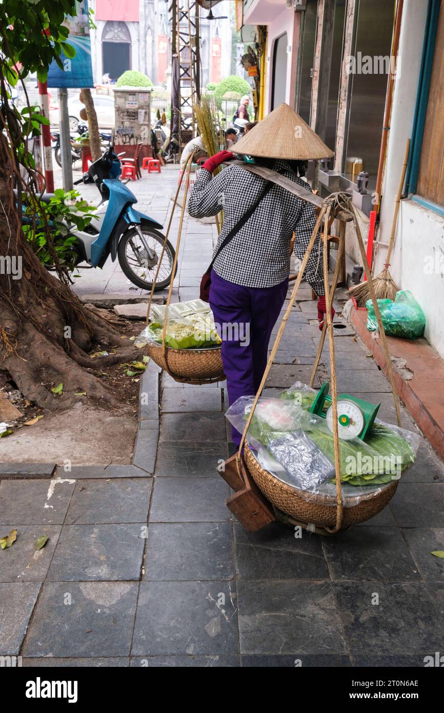 Hanoi, Vietnam. Woman Using Shoulder Poles to Carry Load Stock Photo ...