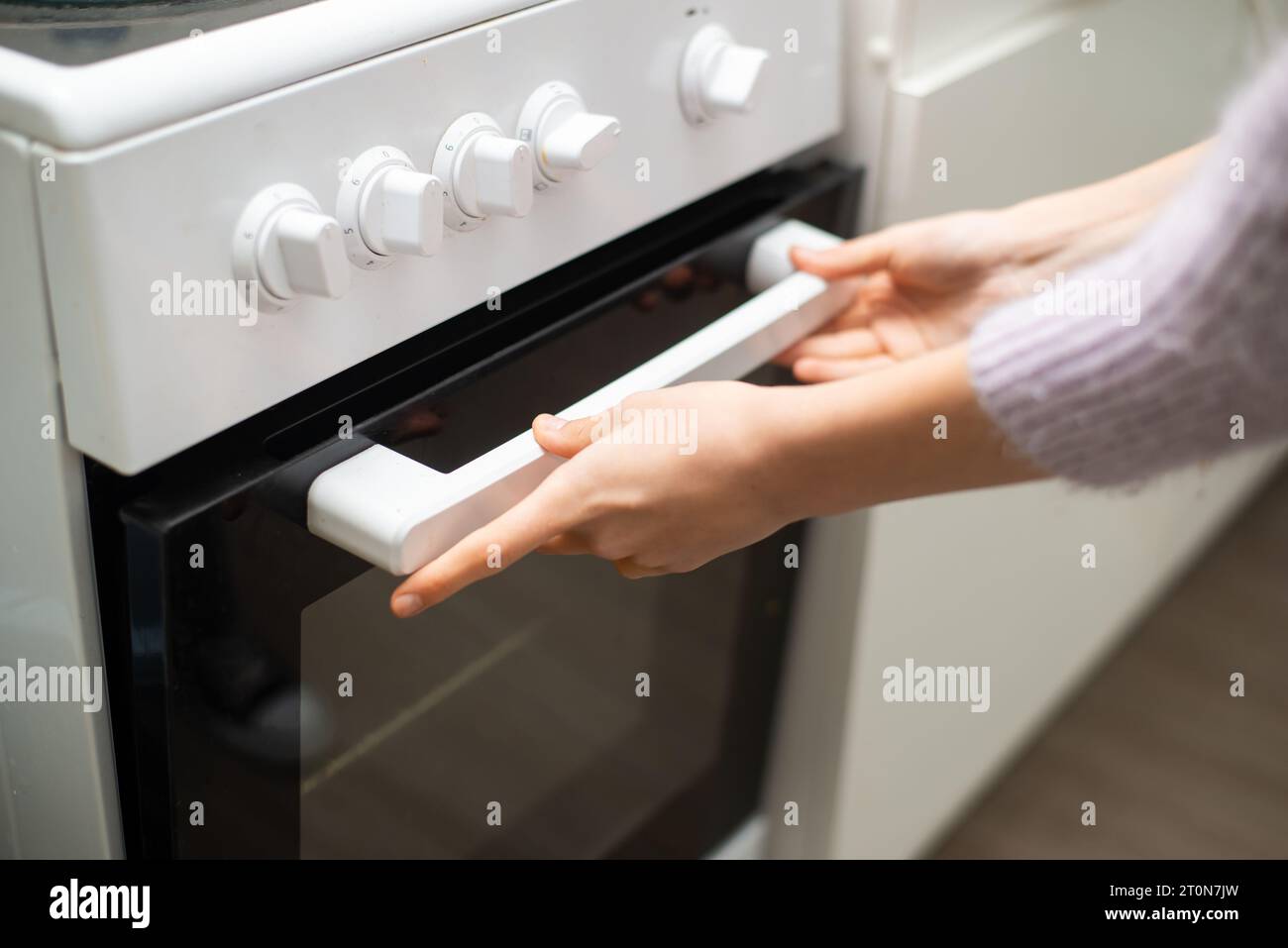 Woman's hands open the oven door Stock Photo - Alamy