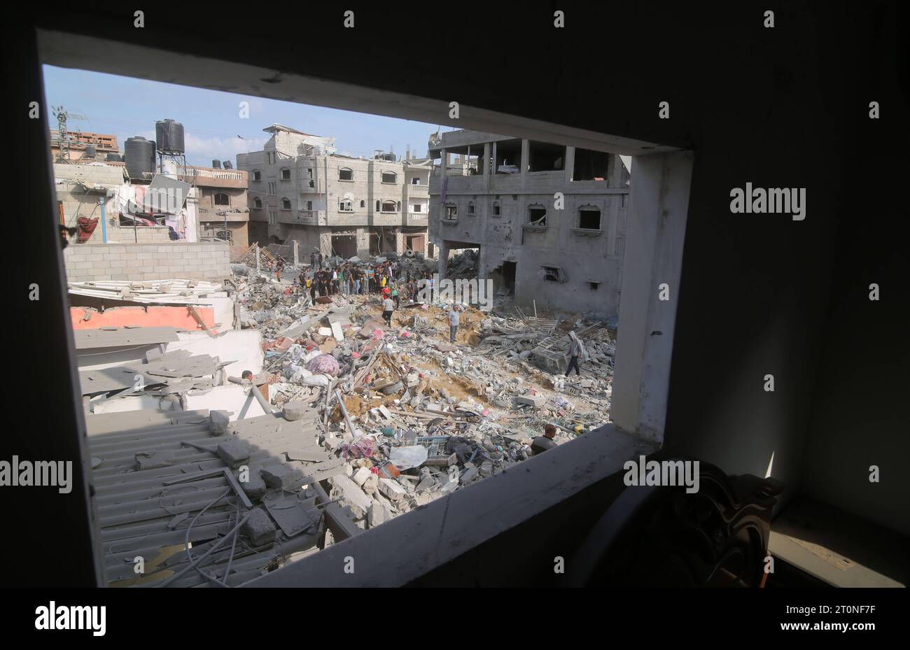 Palestinians inspect the ruins of a building destroyed in Israeli ...