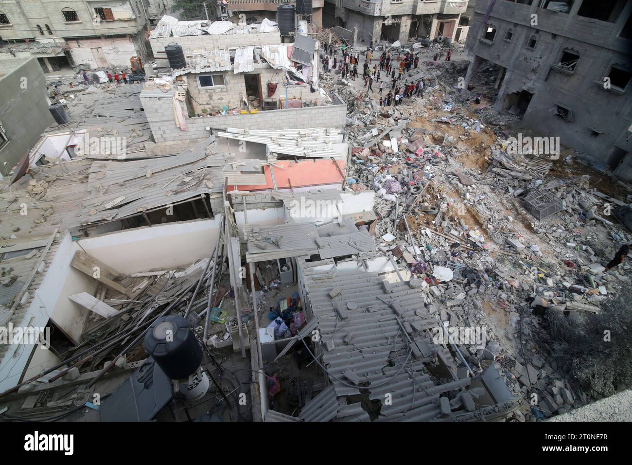 Palestinians inspect the ruins of a building destroyed in Israeli ...