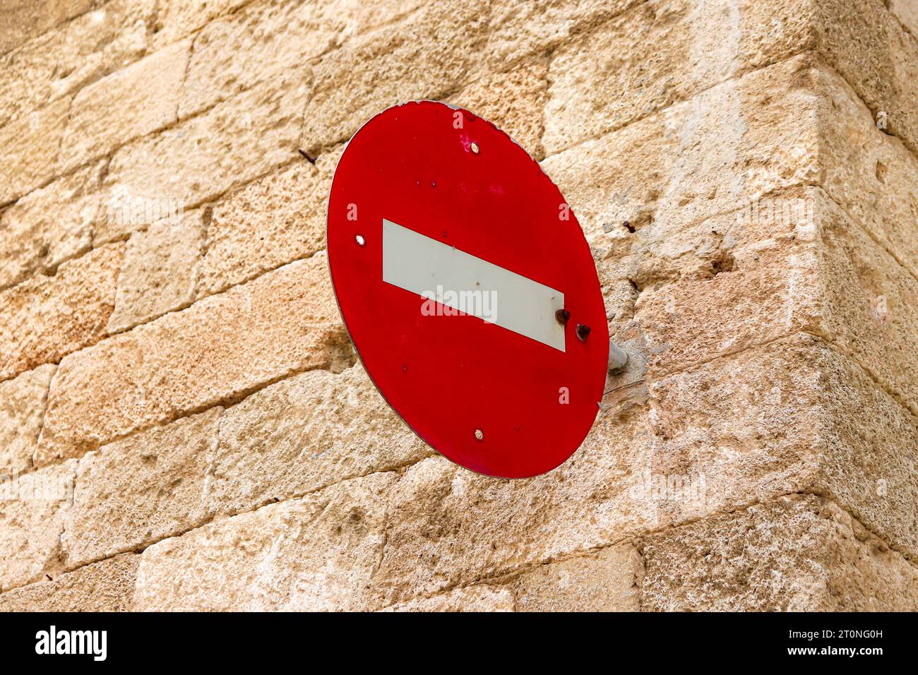 Red do not enter sign hanging from a brick stone background wall ...