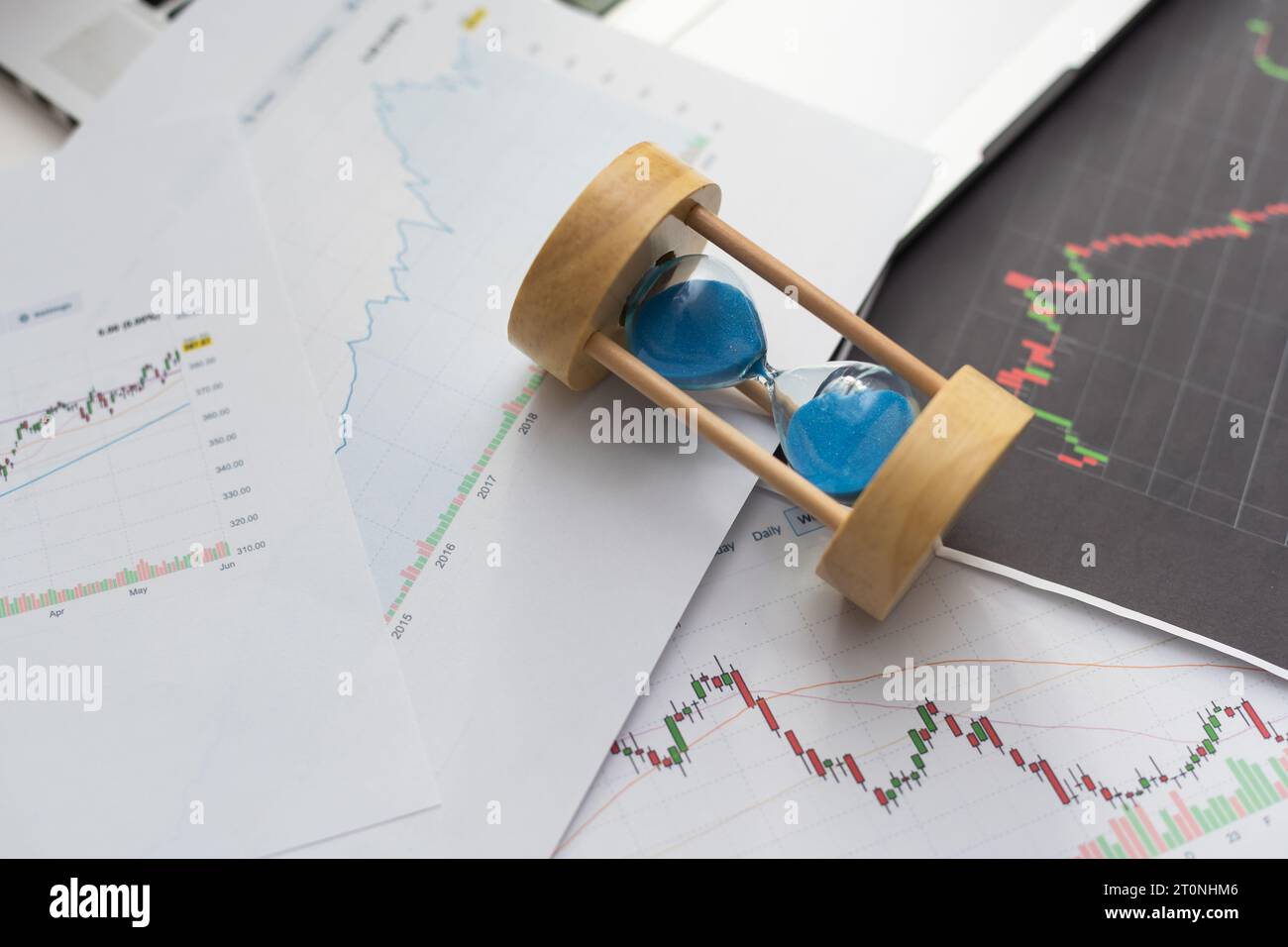 Clock alarm with stock graph chart in laptop screen background.Time ...
