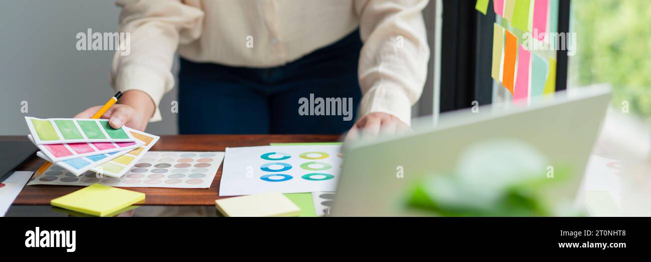 Creative graphic designer holding color swatch to comparing color on ...