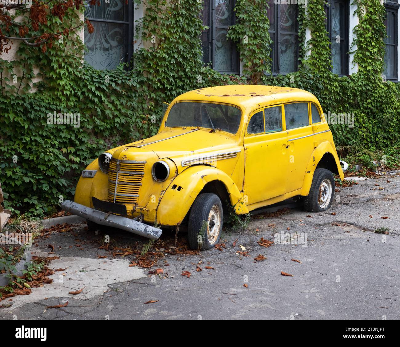 Bright yellow retro car standing near the house. Old rusty car Stock ...