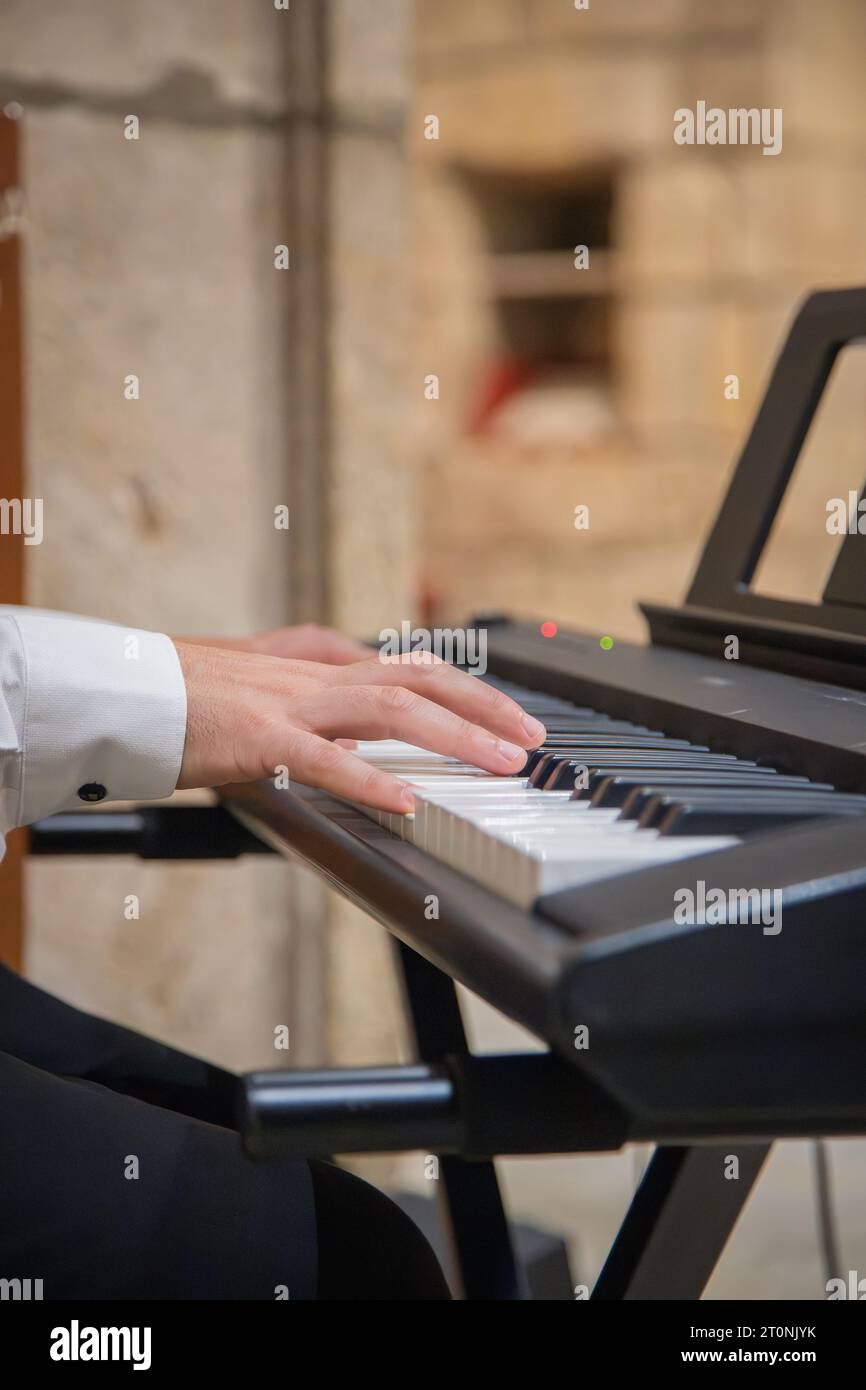 Detail of hands of a Caucasian man in classical clothing playing music ...