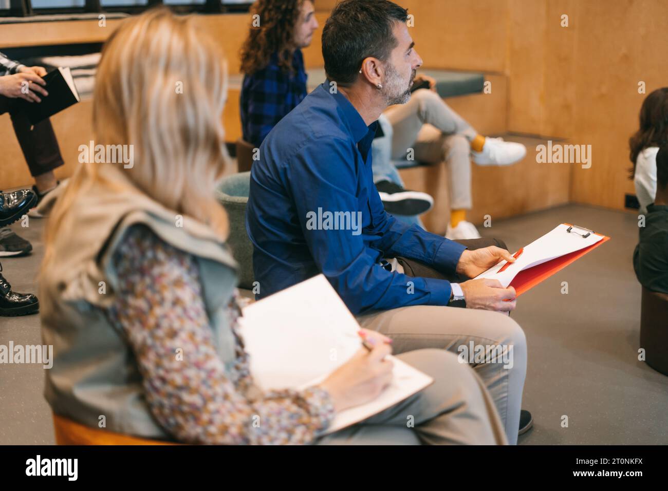 Middle-aged male business person listening to a presentation and ...