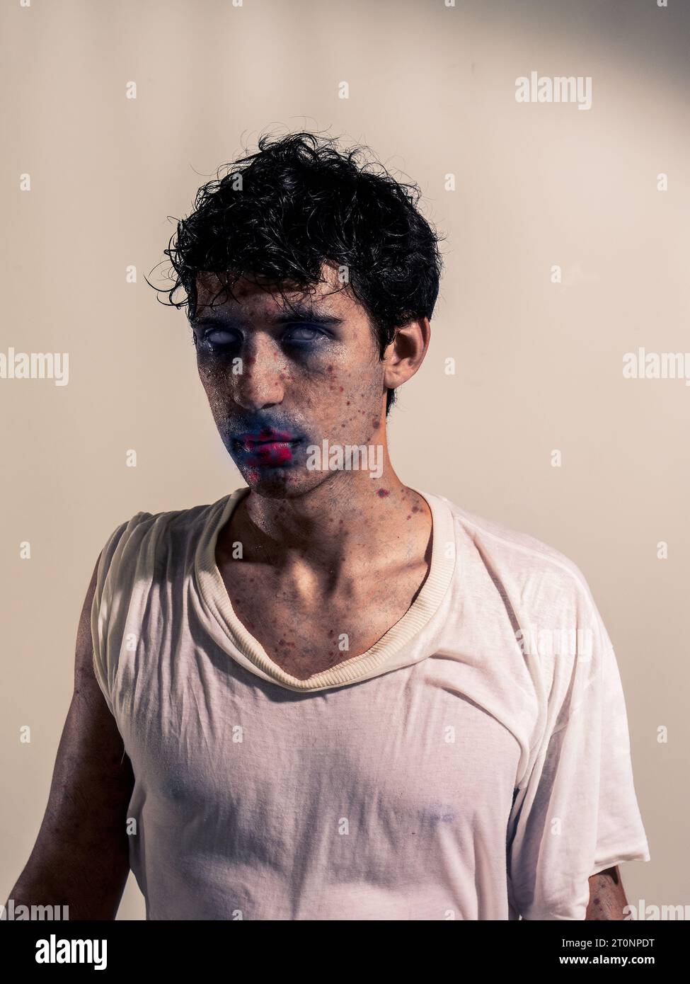 Scary male zombie standing on dark grey background, with white eyes and ...