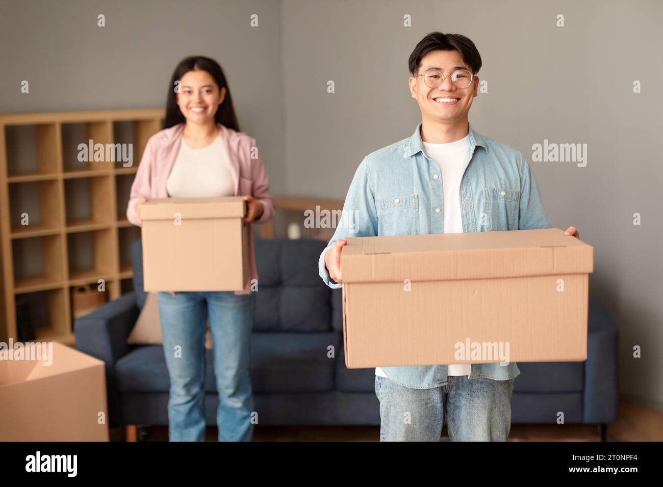 Smiling Korean Couple With Moving Boxes Posing in New Home Stock Photo ...