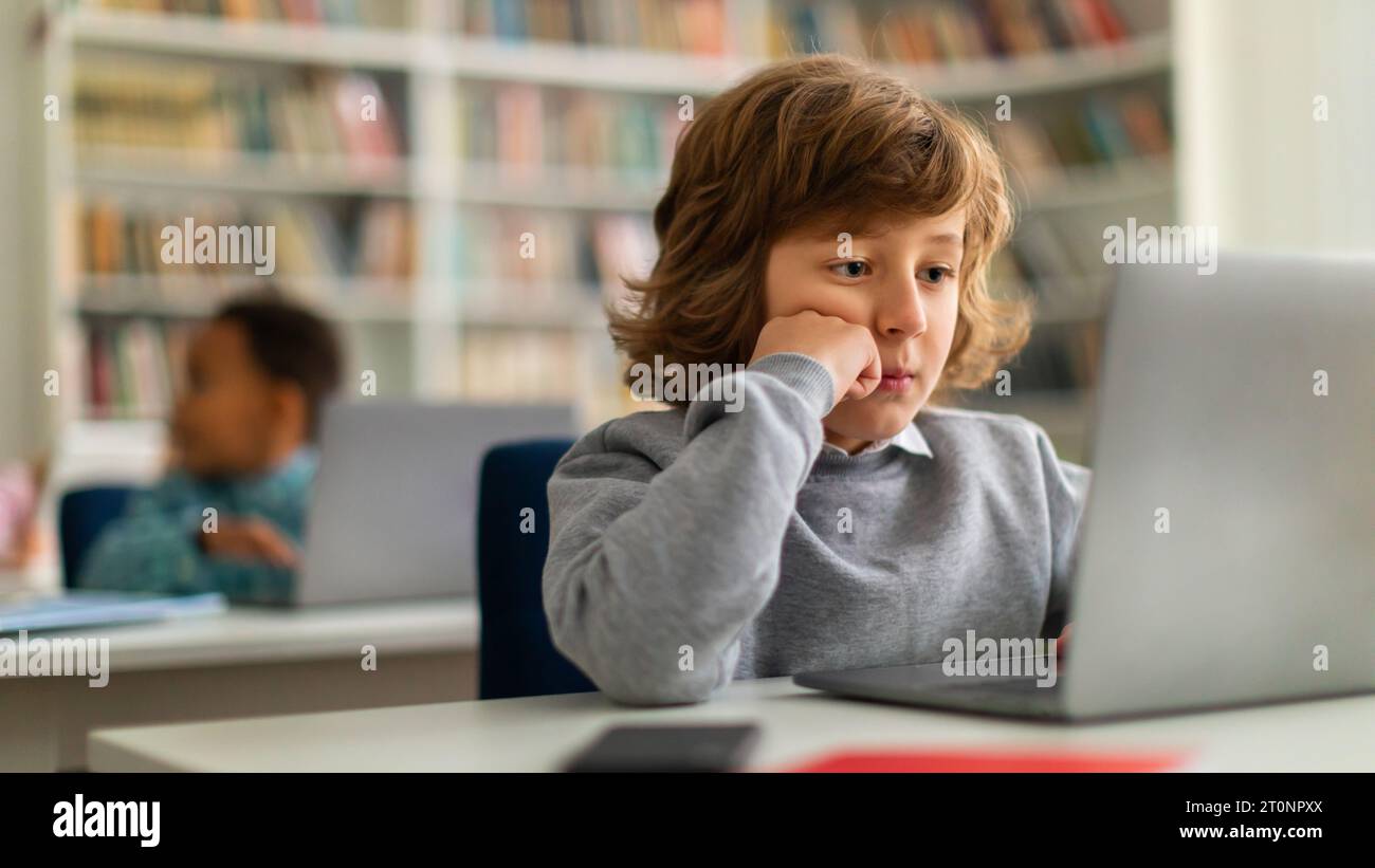 Diverse kids using laptops for learning in classroom Stock Photo - Alamy