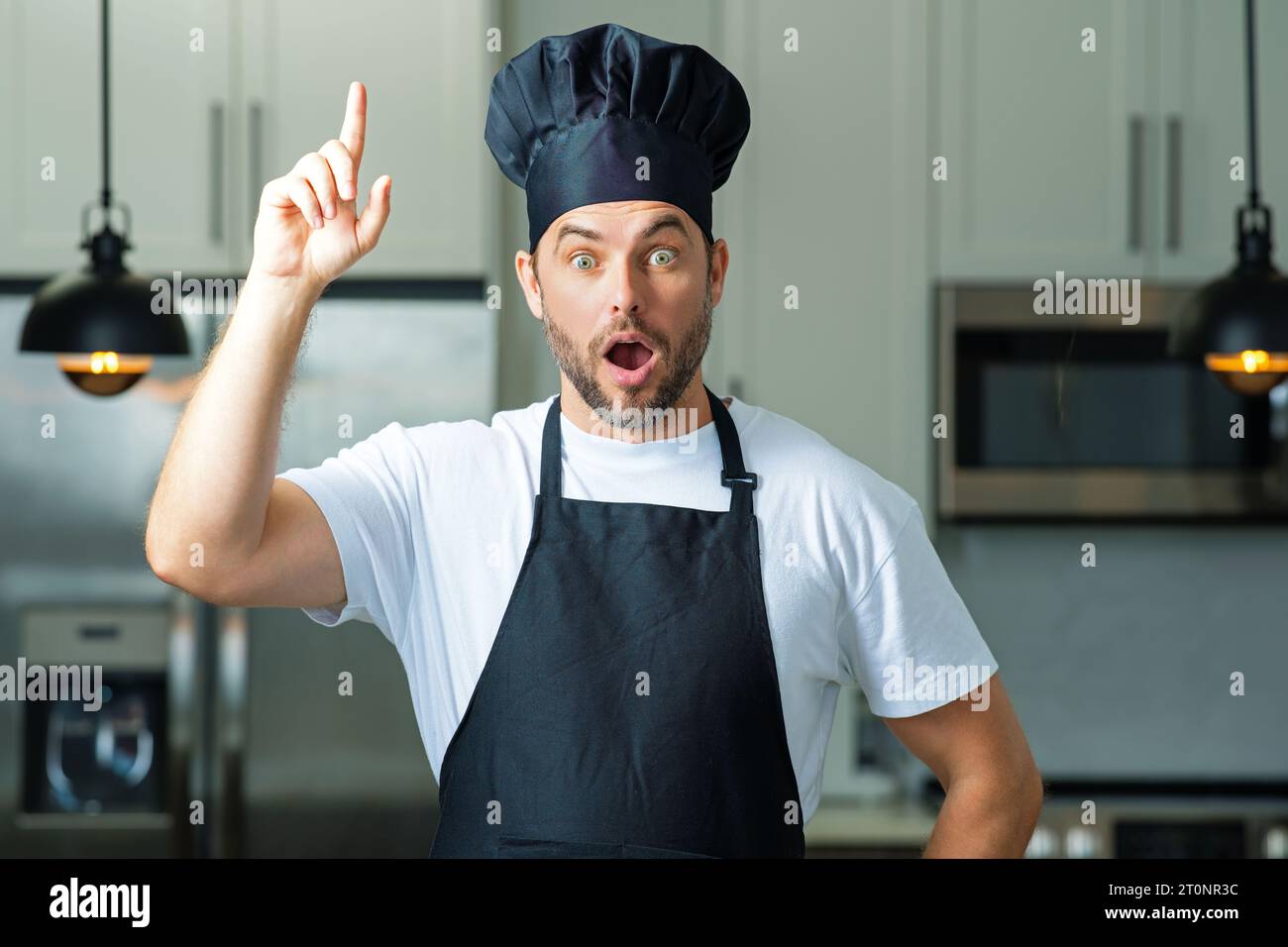 Idea for food. Handsome man chef in uniform cooking in the kitchen ...