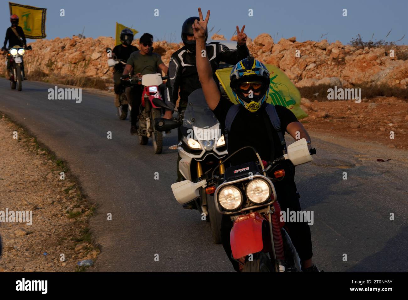 Hezbollah supporters ride their motorcycles, as they pass on a hill ...