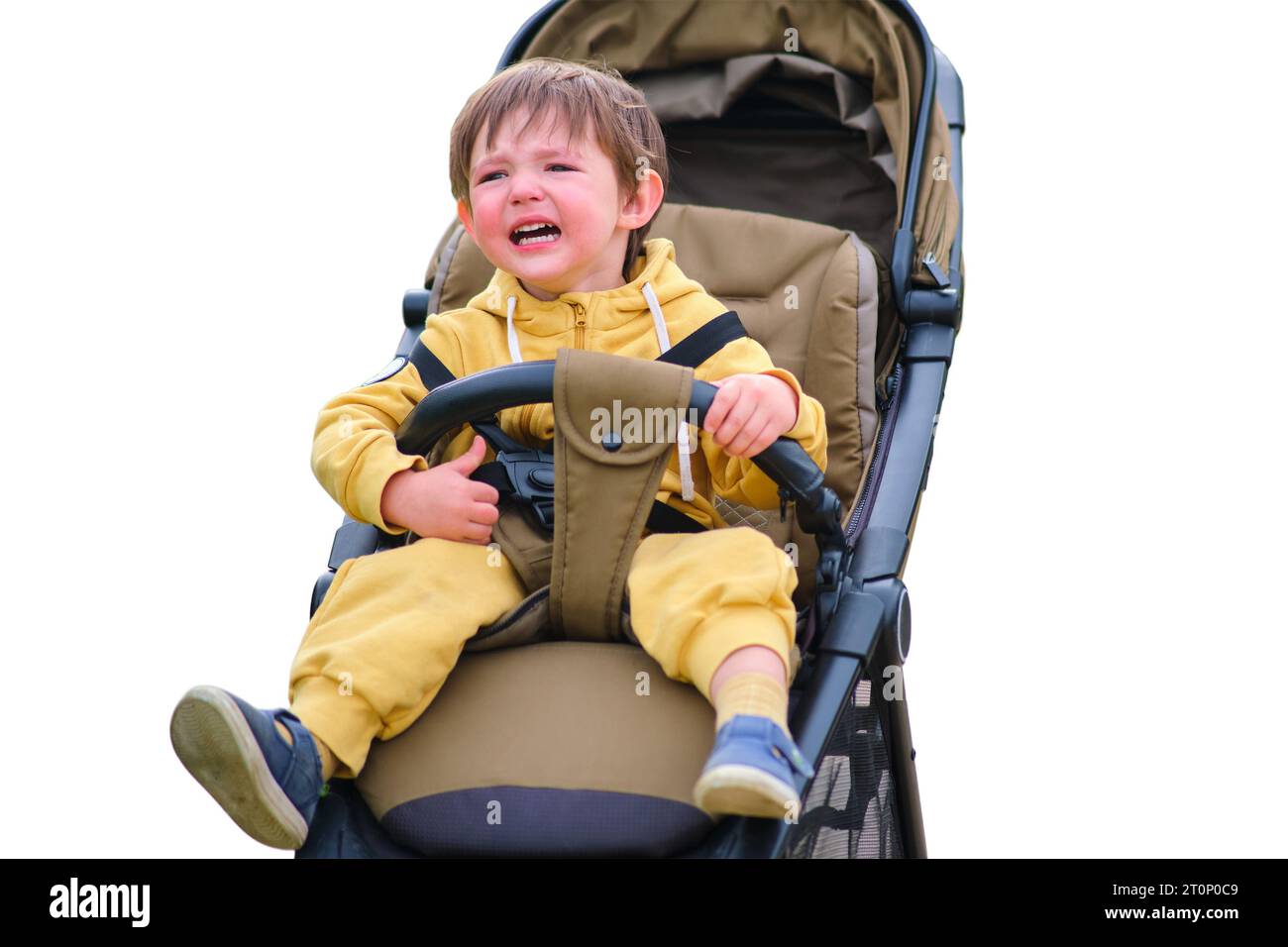 The unhappy child's face shows stress as he crying in the stroller ...