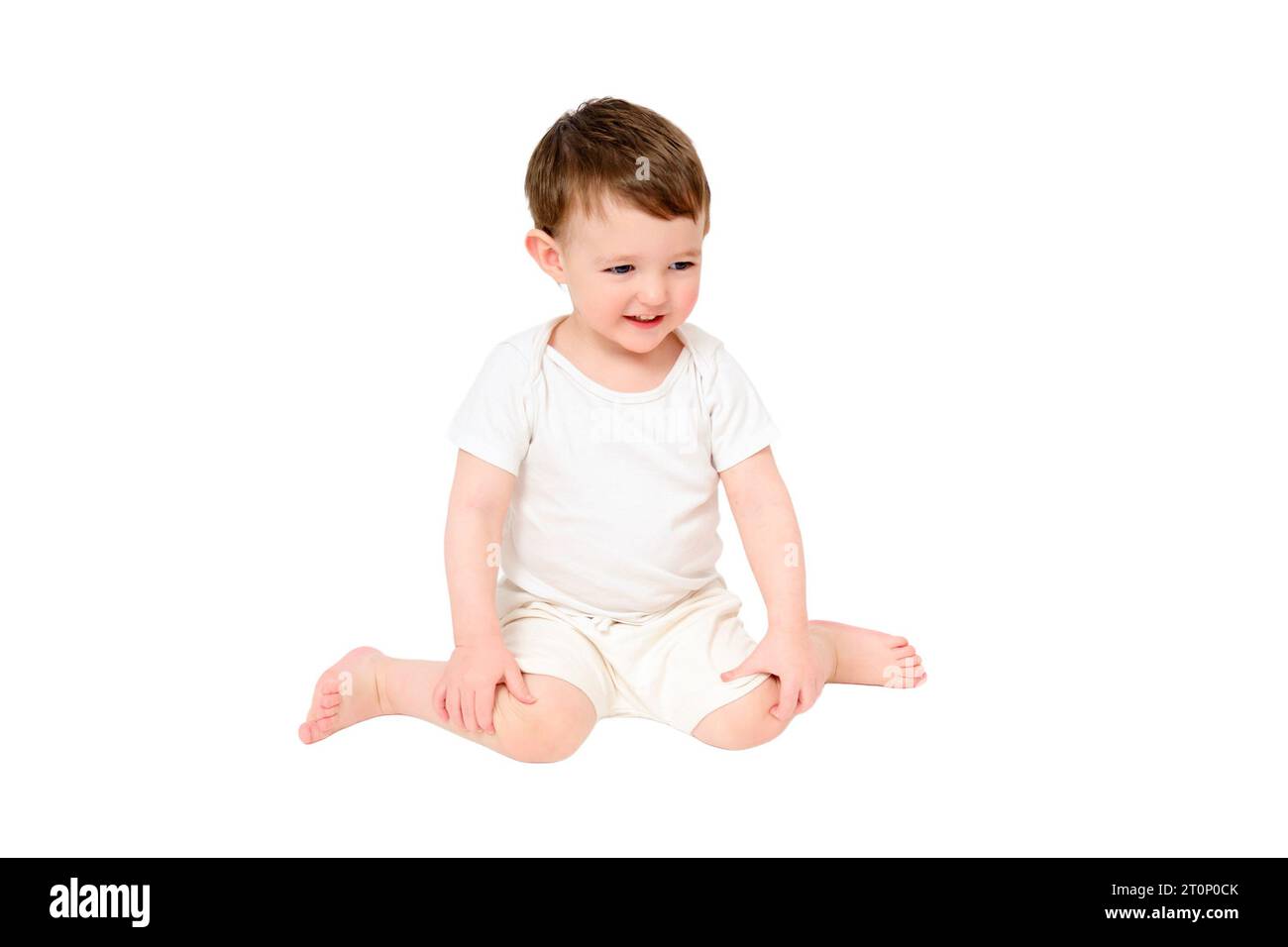 A happy baby is sitting on a studio, isolated on white background. Full ...