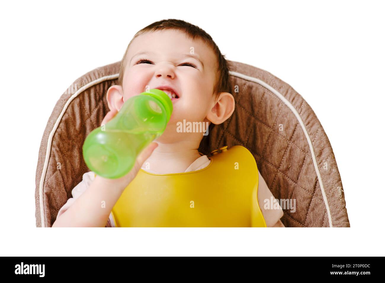 Happy toddler baby drinking from a bottle while sitting on a high chair ...