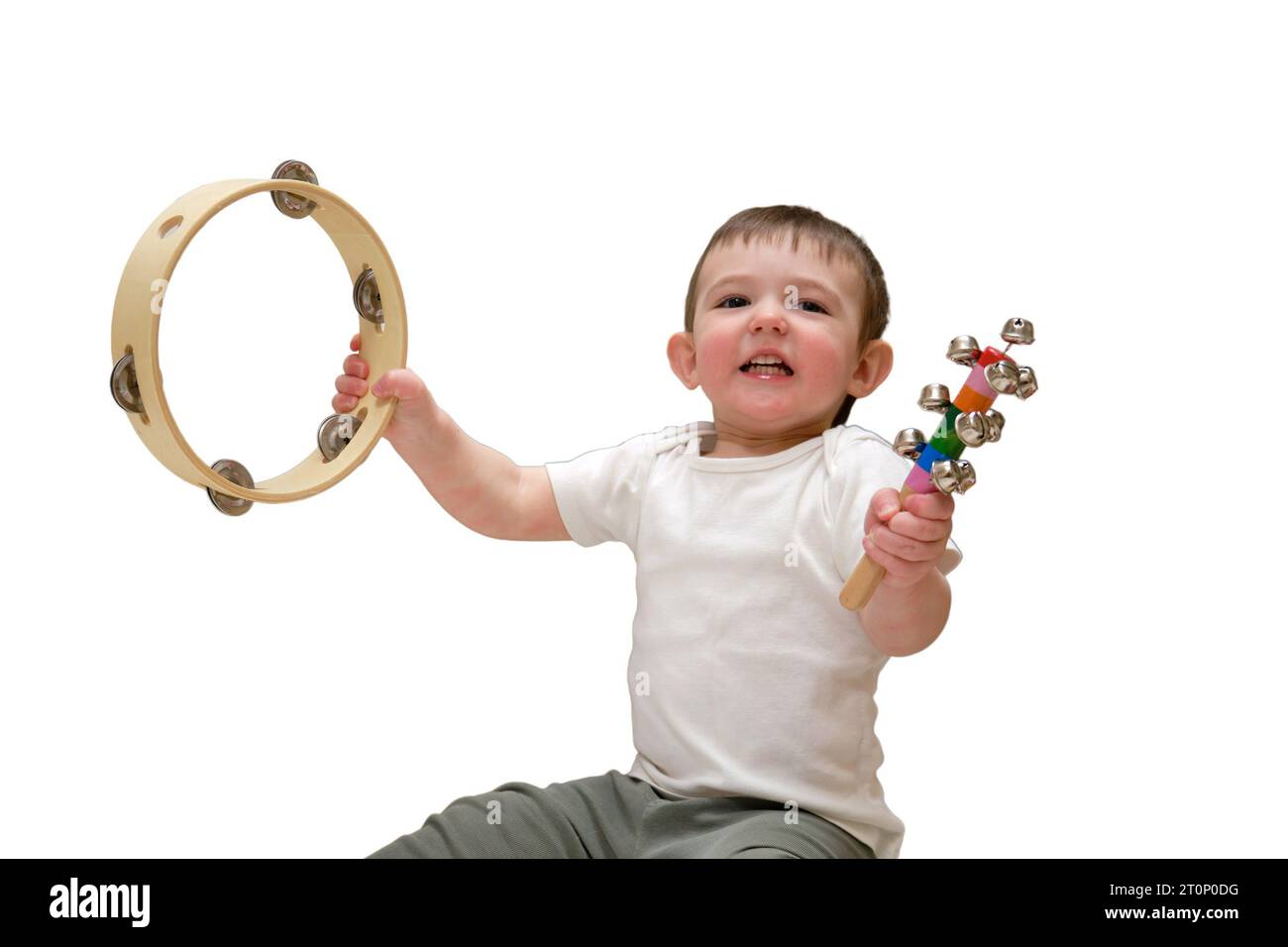 Toddler baby plays the tambourine while sitting on the floor in the ...