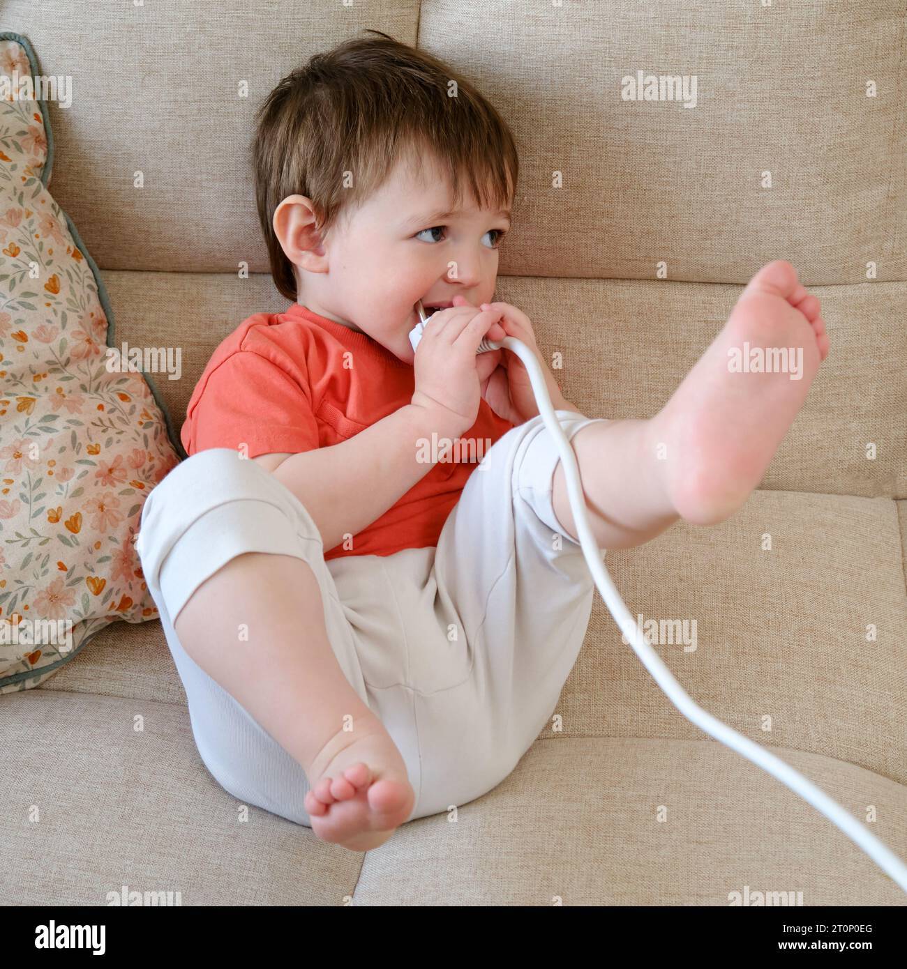 Baby is playing dangerously with an electrical cord inside the house ...