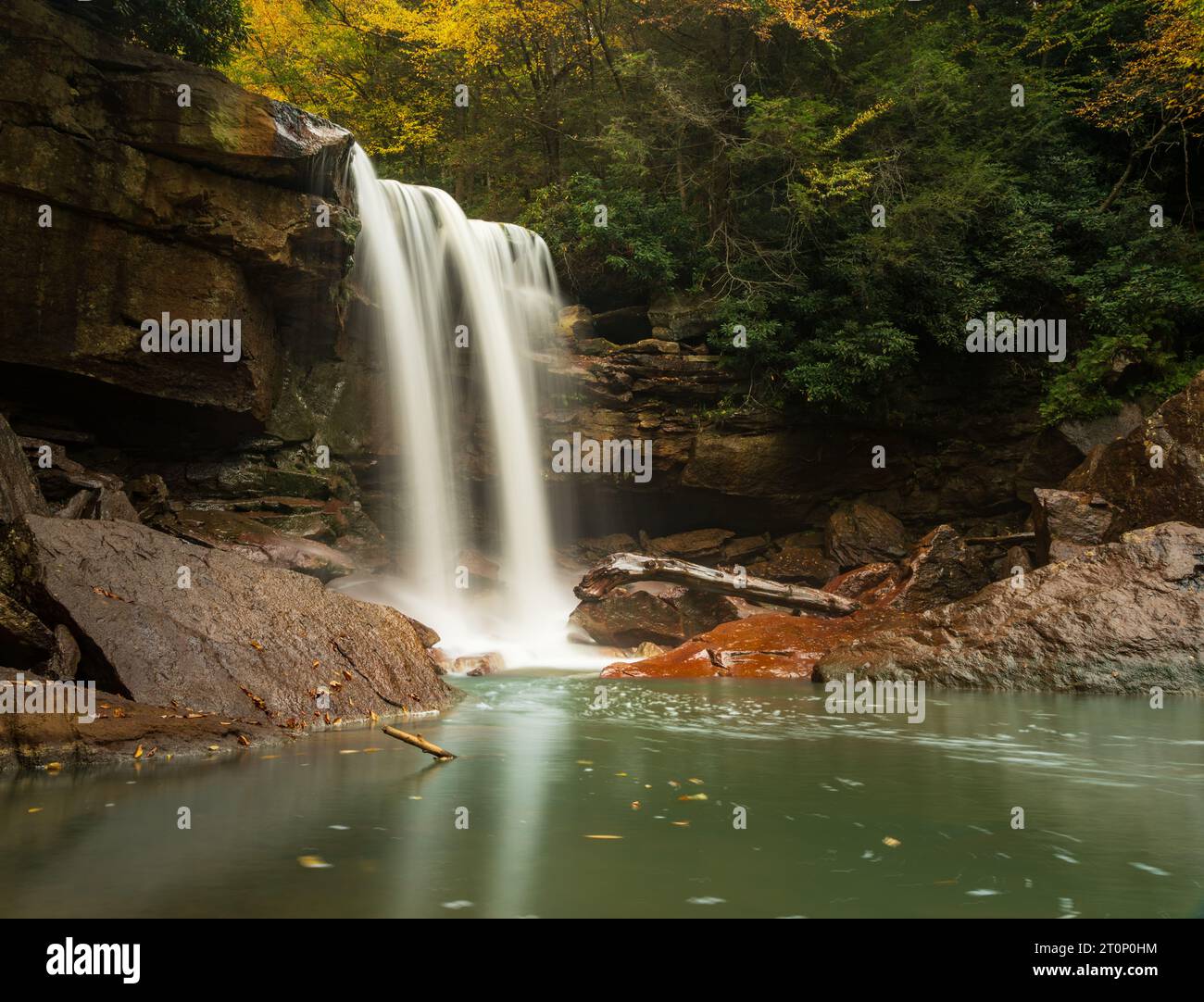 Twin cascades of Douglas Falls and calm lagoon stained with the remains ...