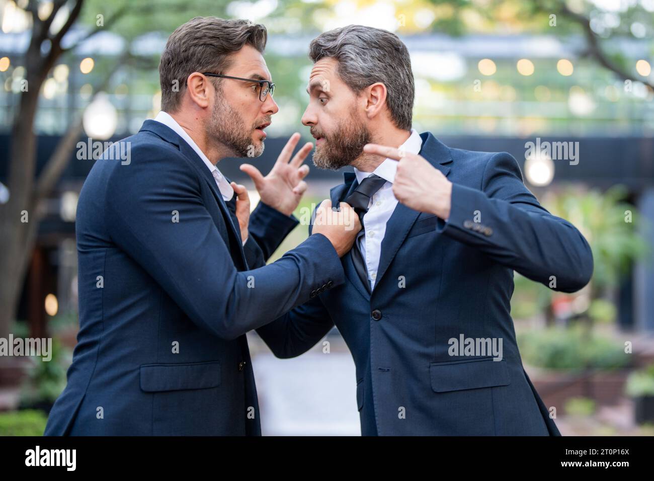 Businessmen fighting outdoor. Angry office workers in city. Disagreed ...