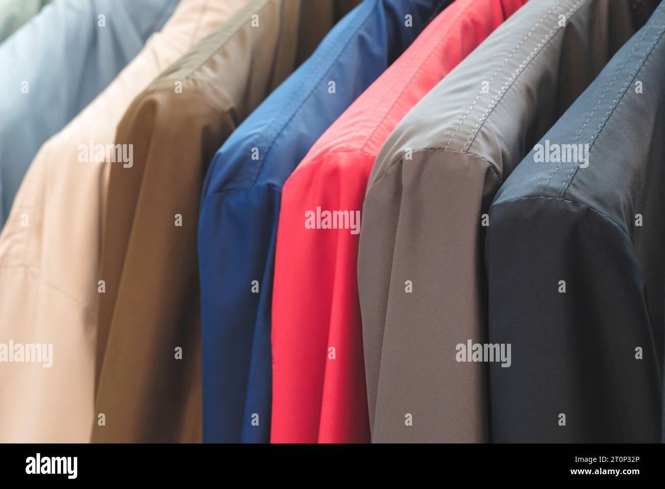 Multi-colored jackets for men on hangers in the store Stock Photo - Alamy