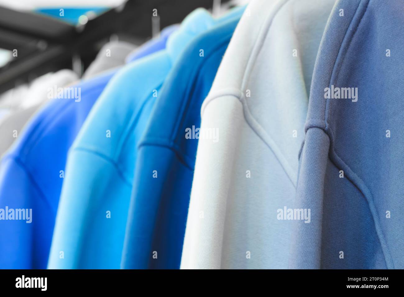 Fashion hoodie clothes on clothing rack Closeup of rainbow color choice ...