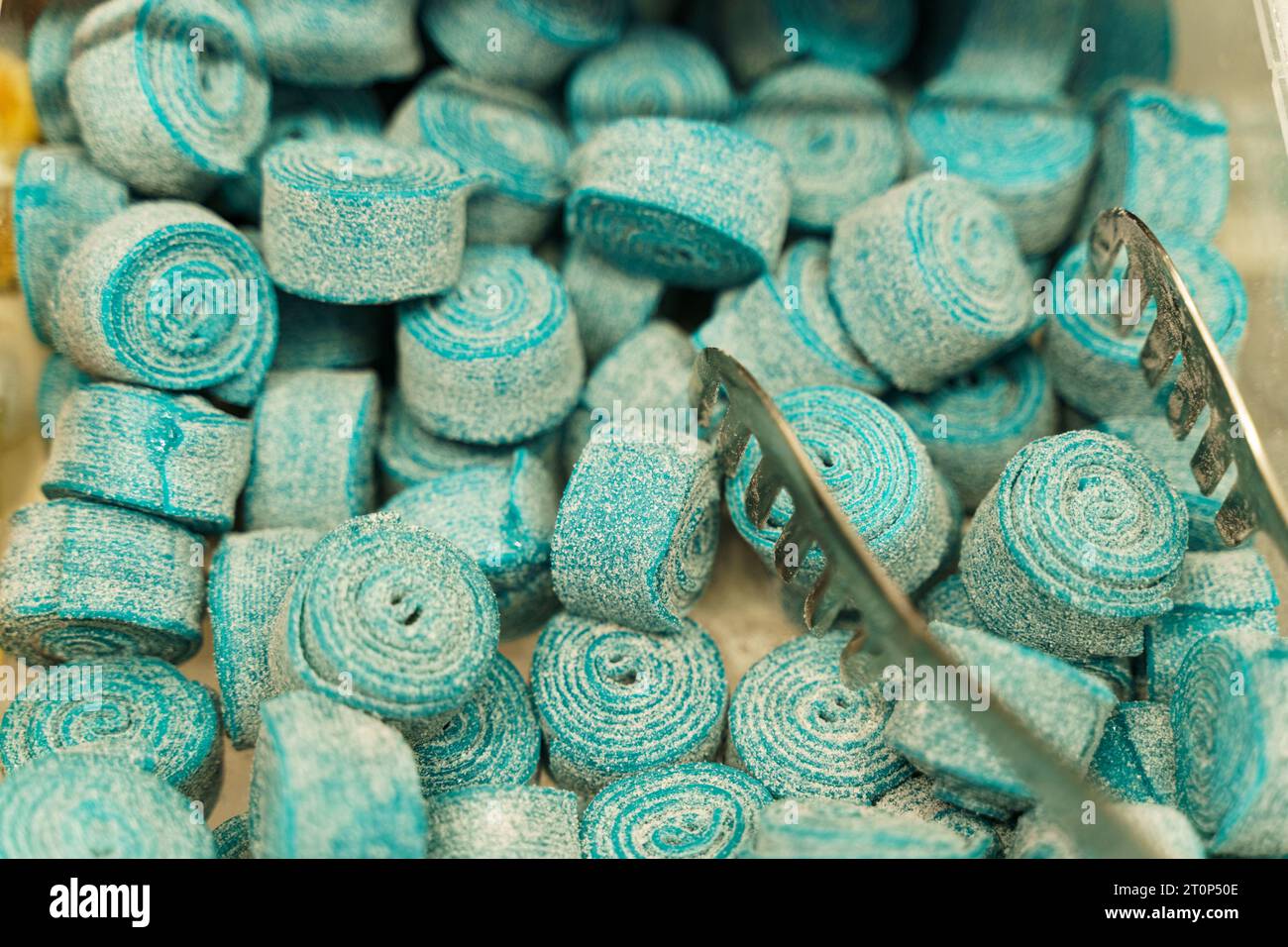 There are candies on the counter - blue chewing marmalade on a roll and ...