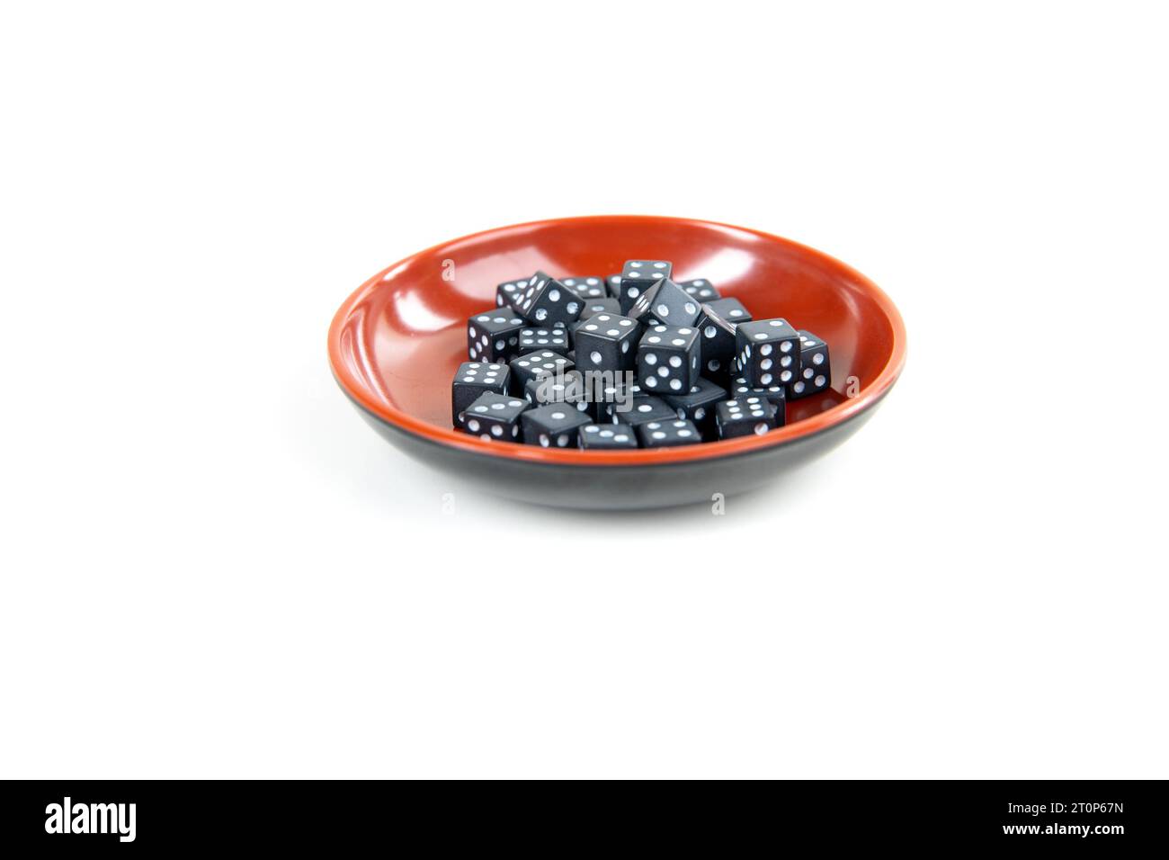 Tiny black and white dice pile in a red bowl isolated over white Stock ...