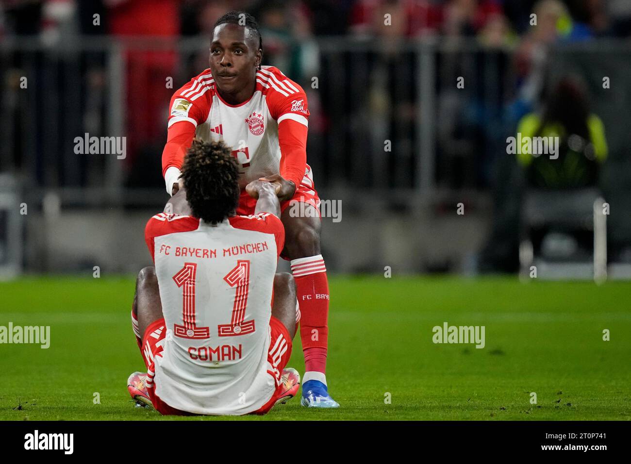 Bayern's Mathys Tel, background lifts Bayern's Kingsley Coman during ...