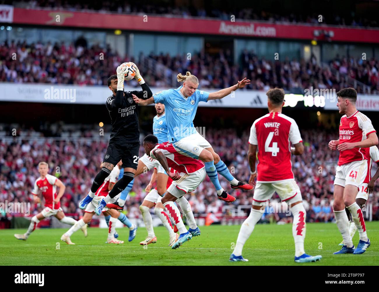 Arsenal goalkeeper David Raya (left) saves the ball from Manchester ...