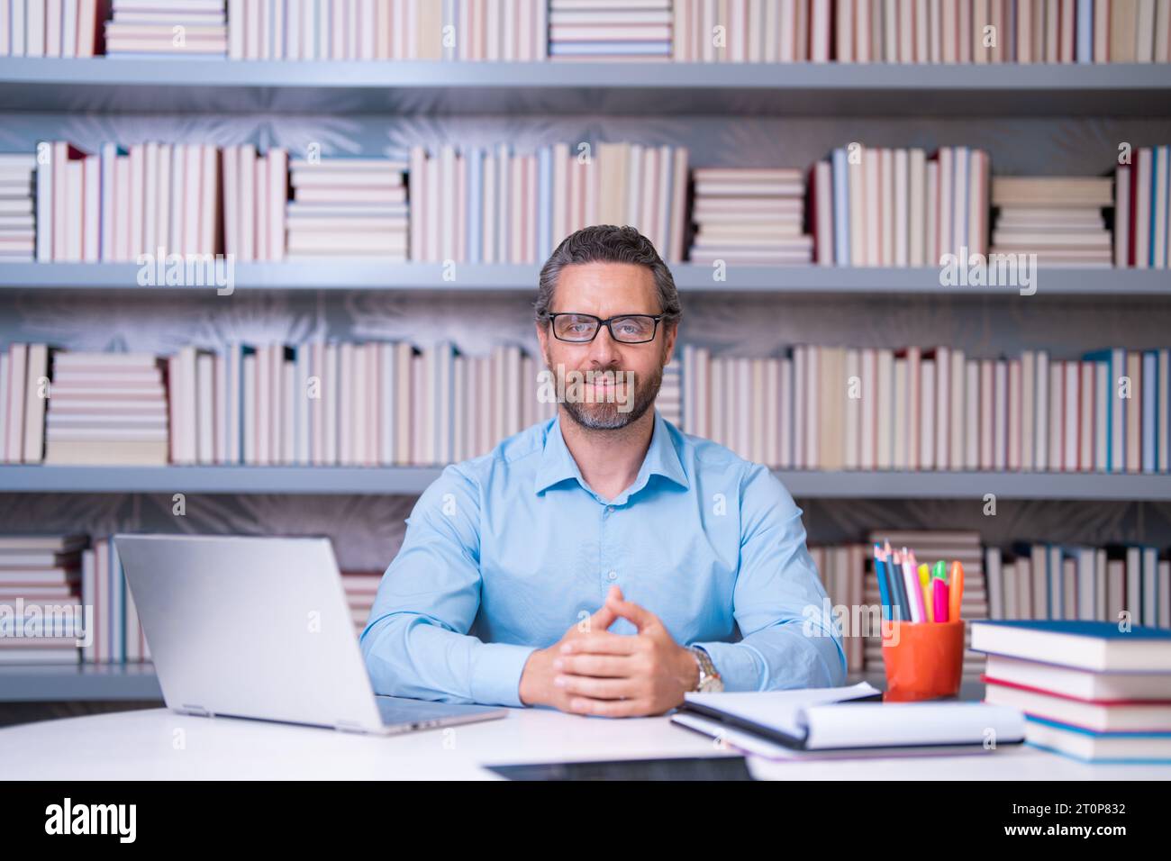 Portrait of teacher in library classroom. Handsome teacher in ...