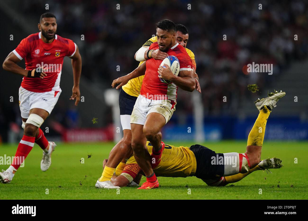 Tonga's George Moala (centre) is tackled by Romania's Costel Burtila ...