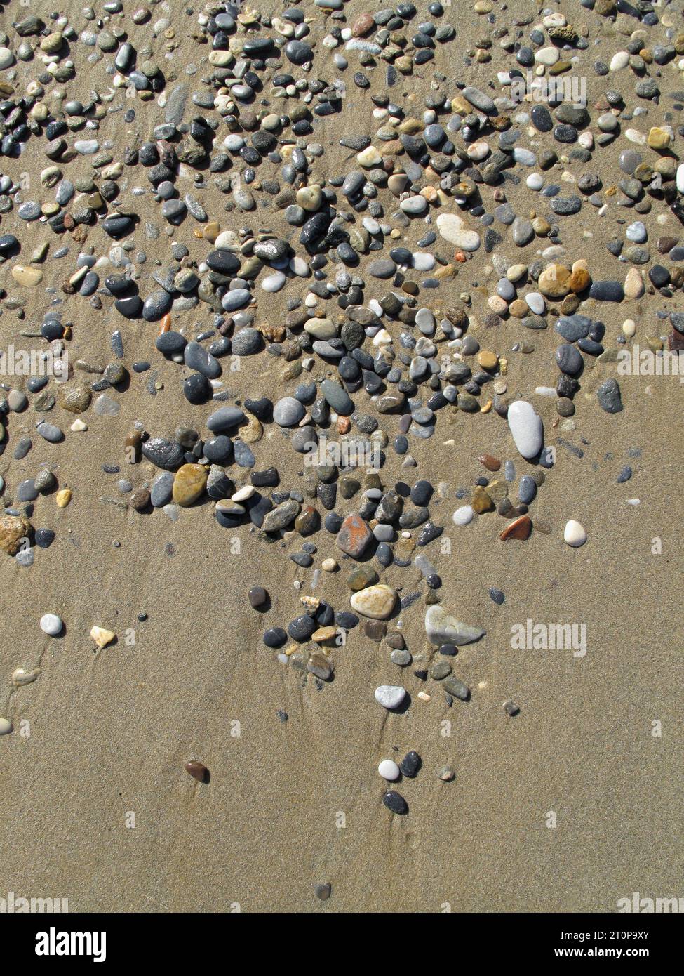 Wet sand background with sea pebbles Stock Photo - Alamy
