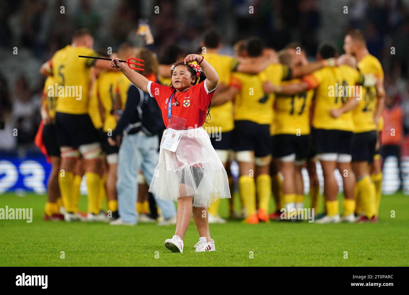 A young family member of a Tonga player celebrates the win in front of ...