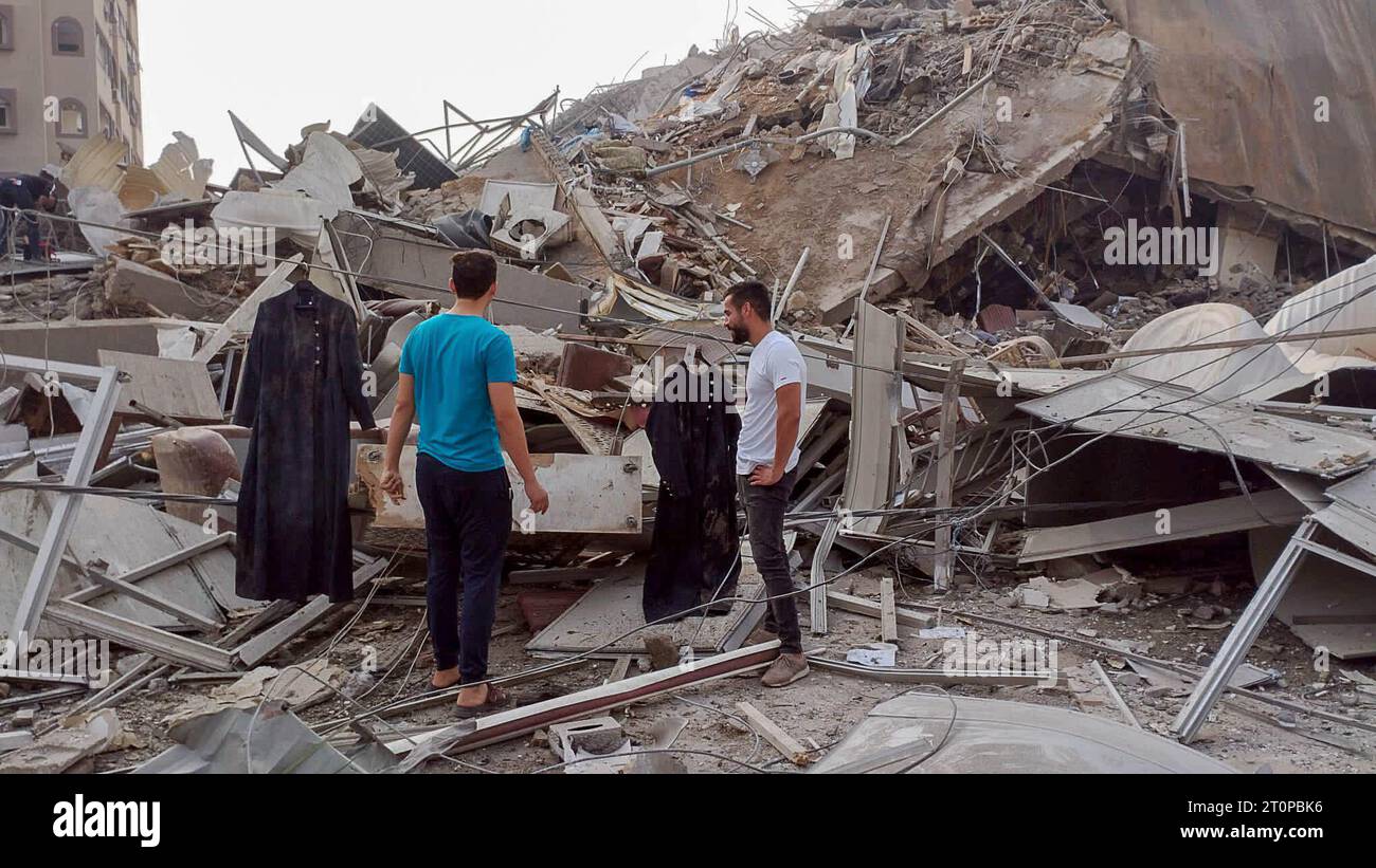 Gaza, Palestine. 8th Oct, 2023. (INT) Palestinians inspect the ruins of ...