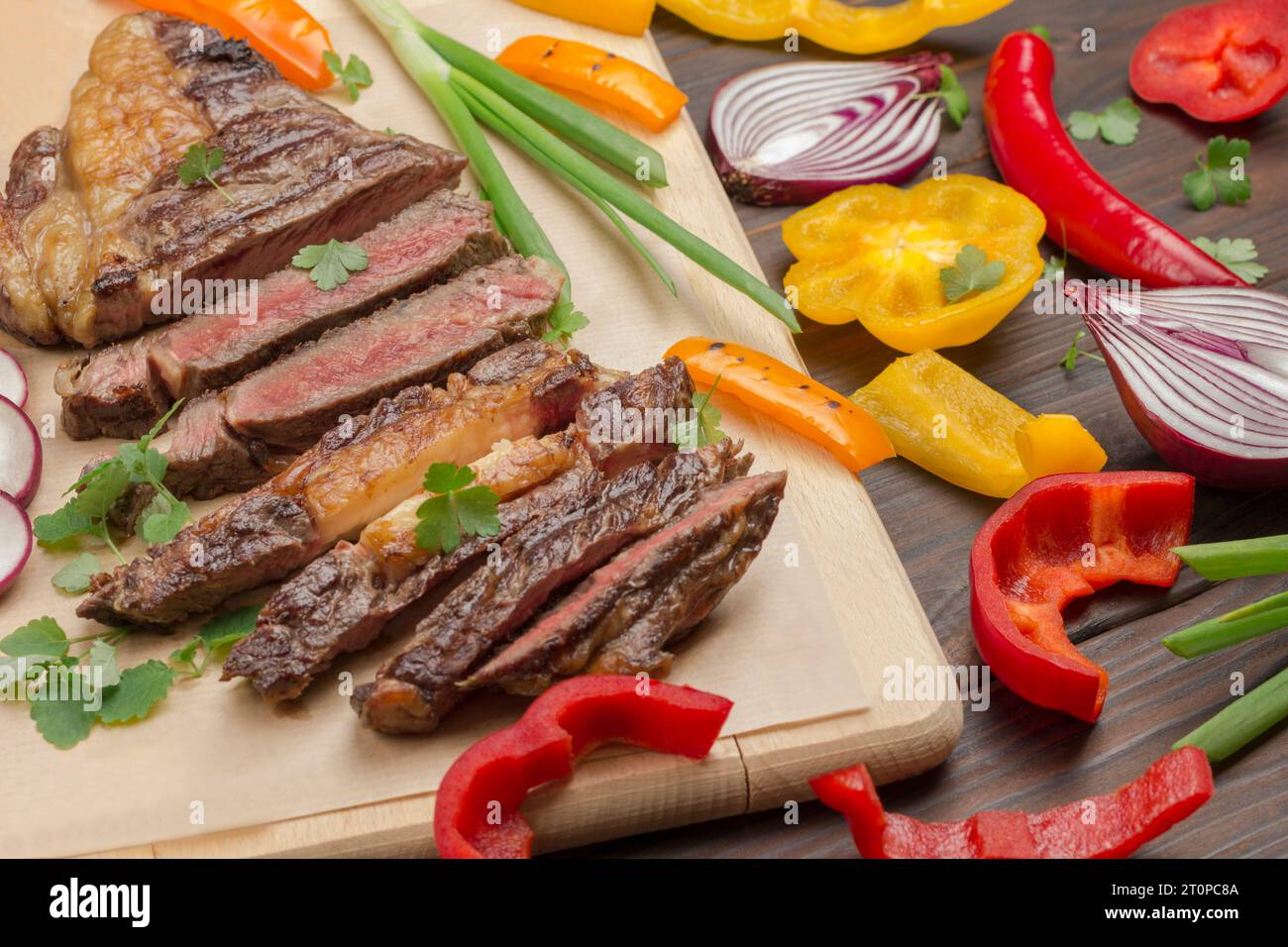 Marbled beef steak medium rare with vegetables on wooden cutting board ...